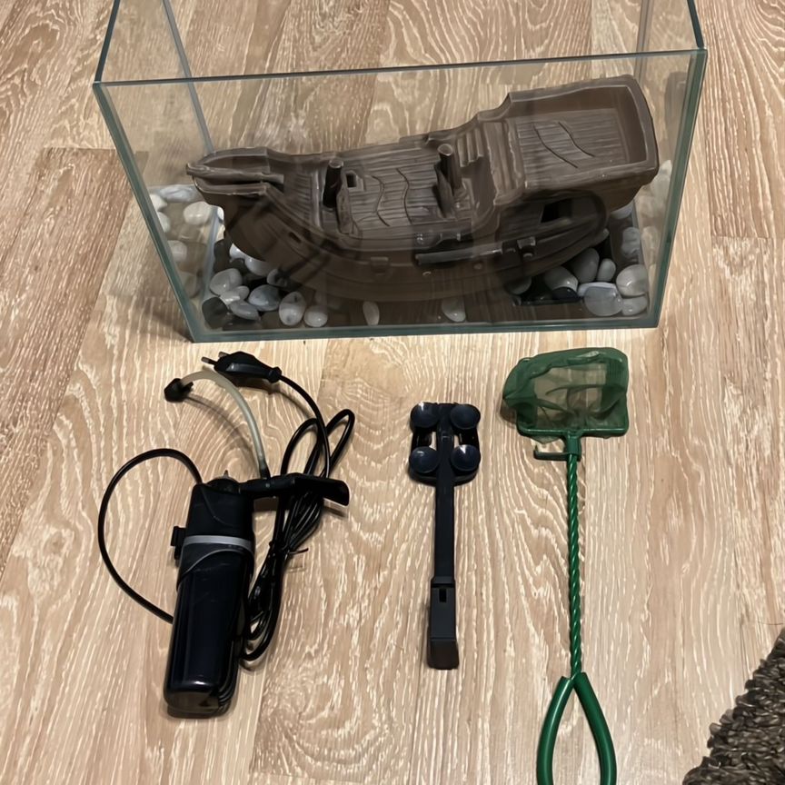 Аквариум с декоративными камнями, кораблем